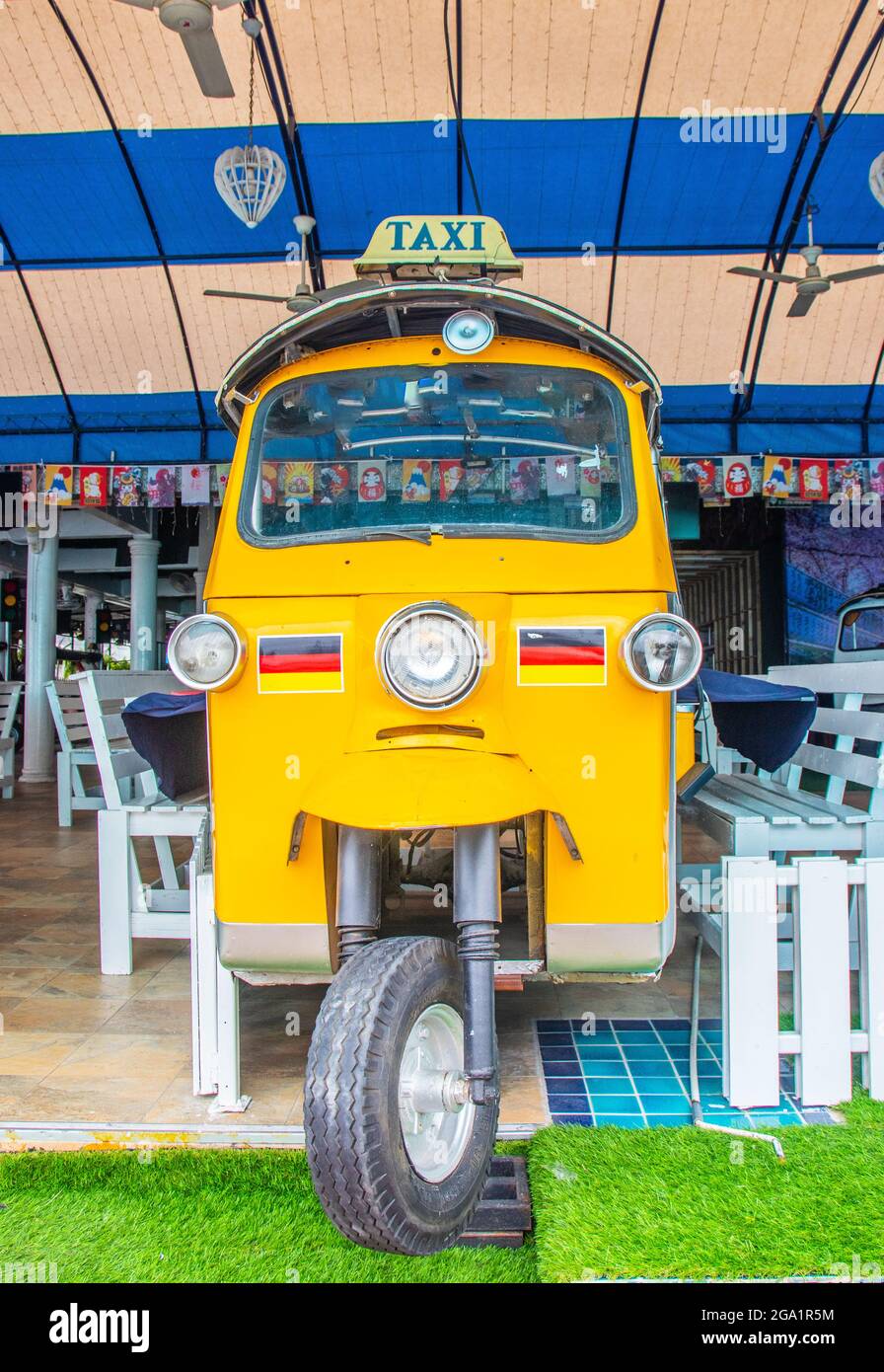 a yellow Tuk Tuk Taxi Vehicle in an open air bar Stock Photo - Alamy