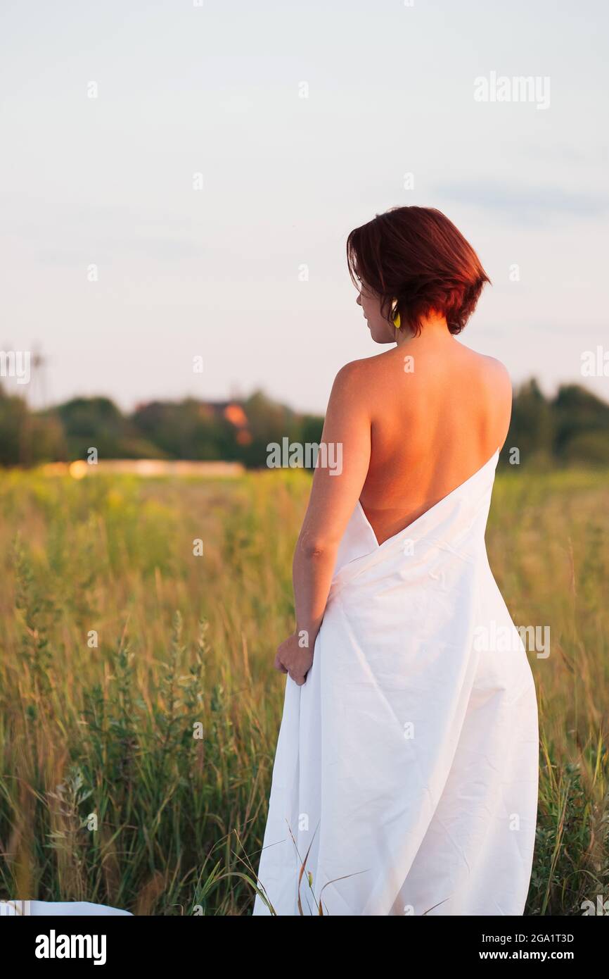 Charming caucasian woman in a field at sunset in summer back view Stock ...