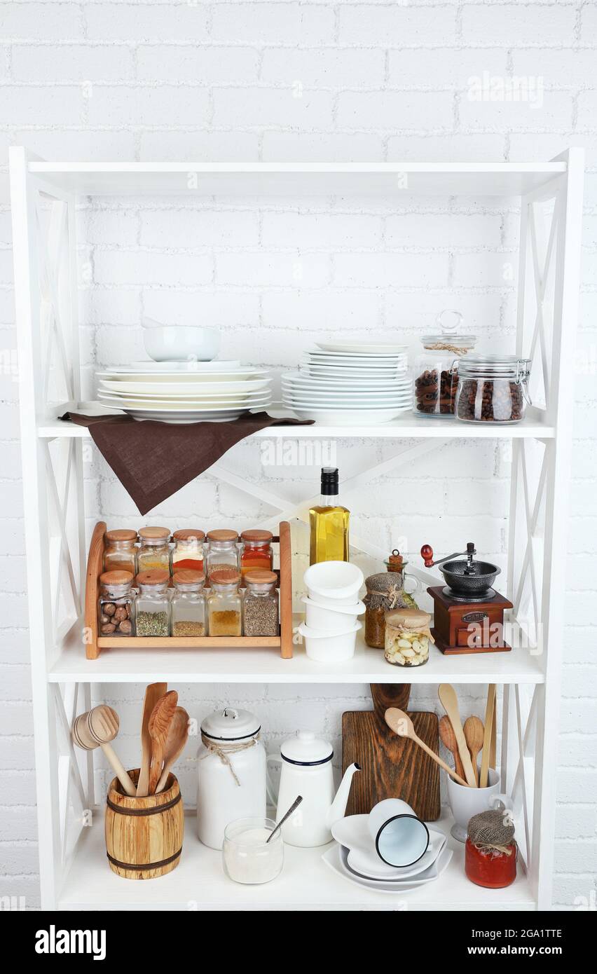 Kitchen shelving with dishes on white brick wall background Stock Photo ...
