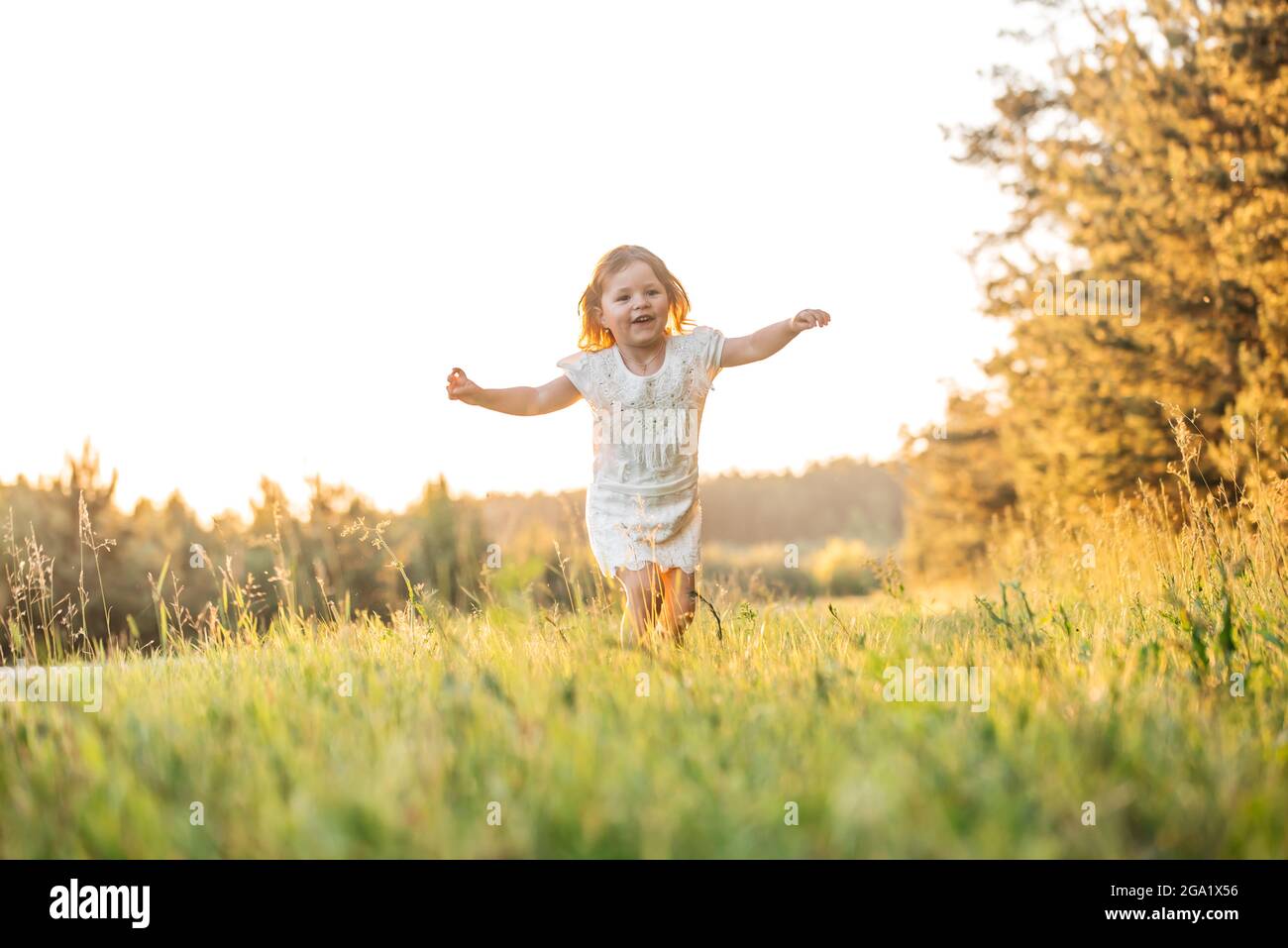 happy baby smiling. little girl running at sunset outdoor Stock Photo ...