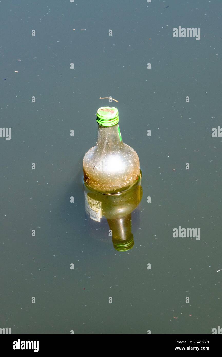 empty bottle floating in river, empty bottle discarded and thrown into ...