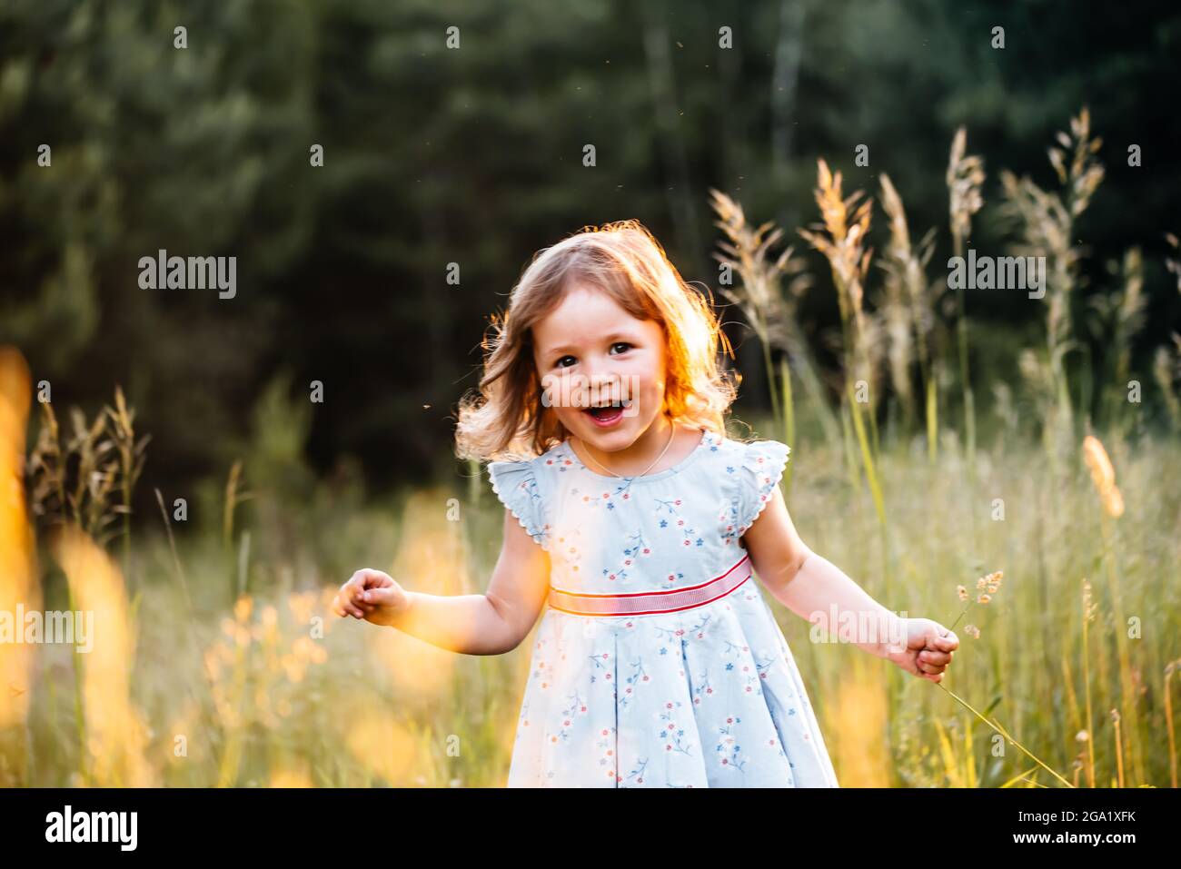 happy baby smiling. little girl running at sunset outdoor Stock Photo ...