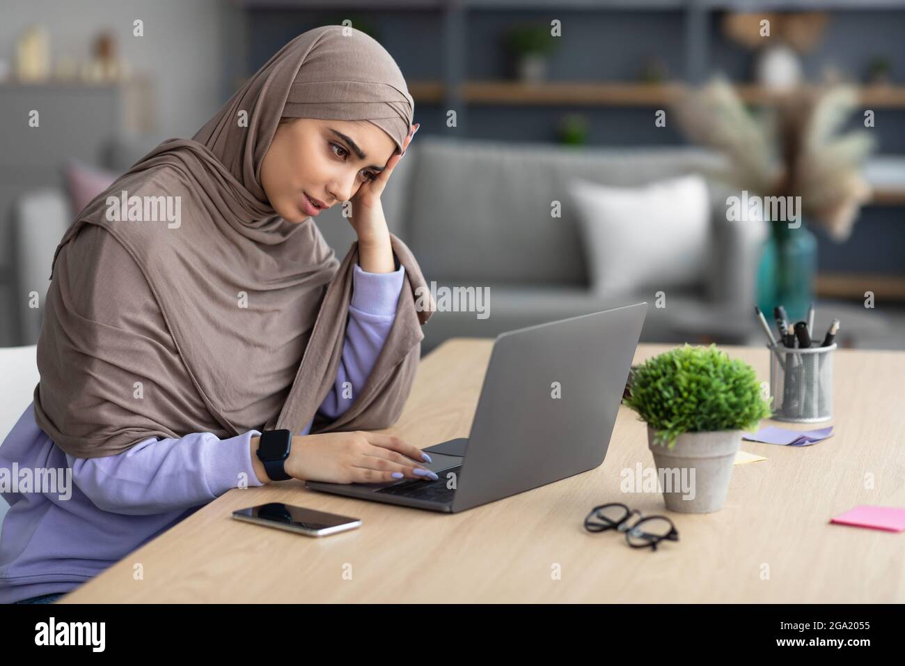 Tired muslim woman sitting at desk, using computer Stock Photo - Alamy