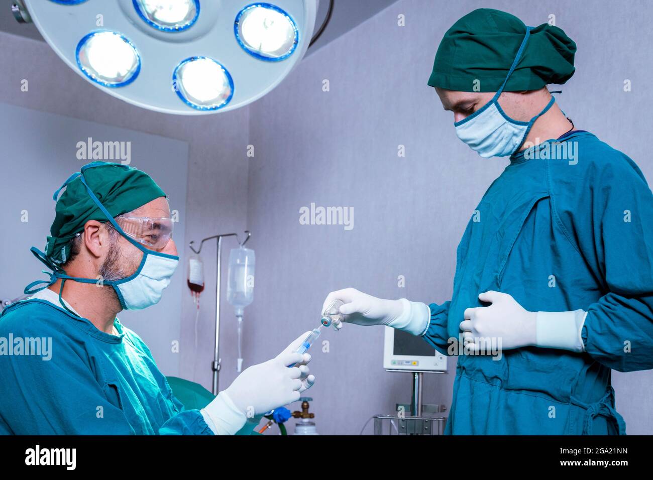 doctor and nurse holding syringe and bottle of anesthesia medicine to ...