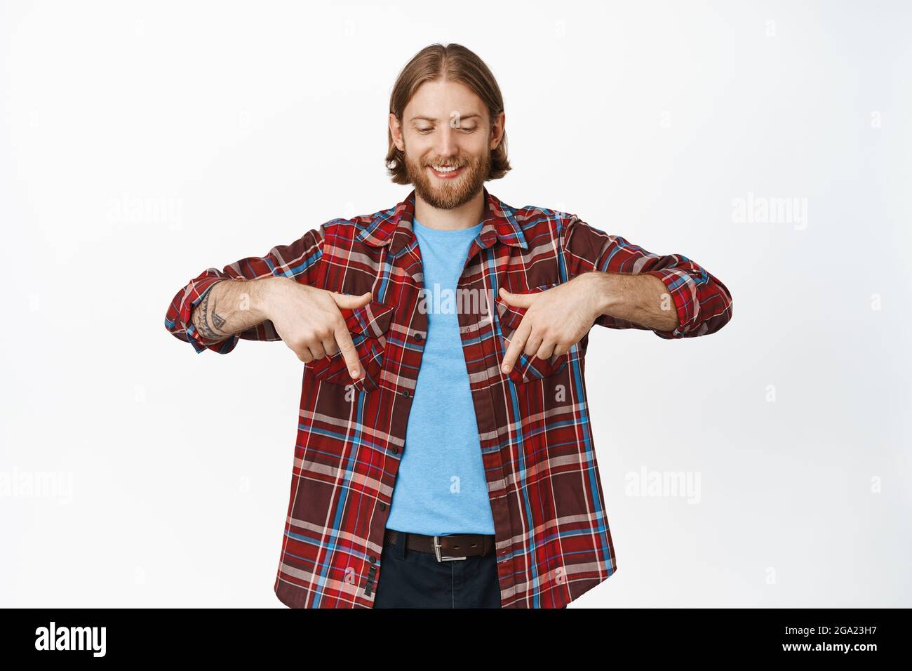 Handsome smiling blond man with beard, looking and pointing fingers ...