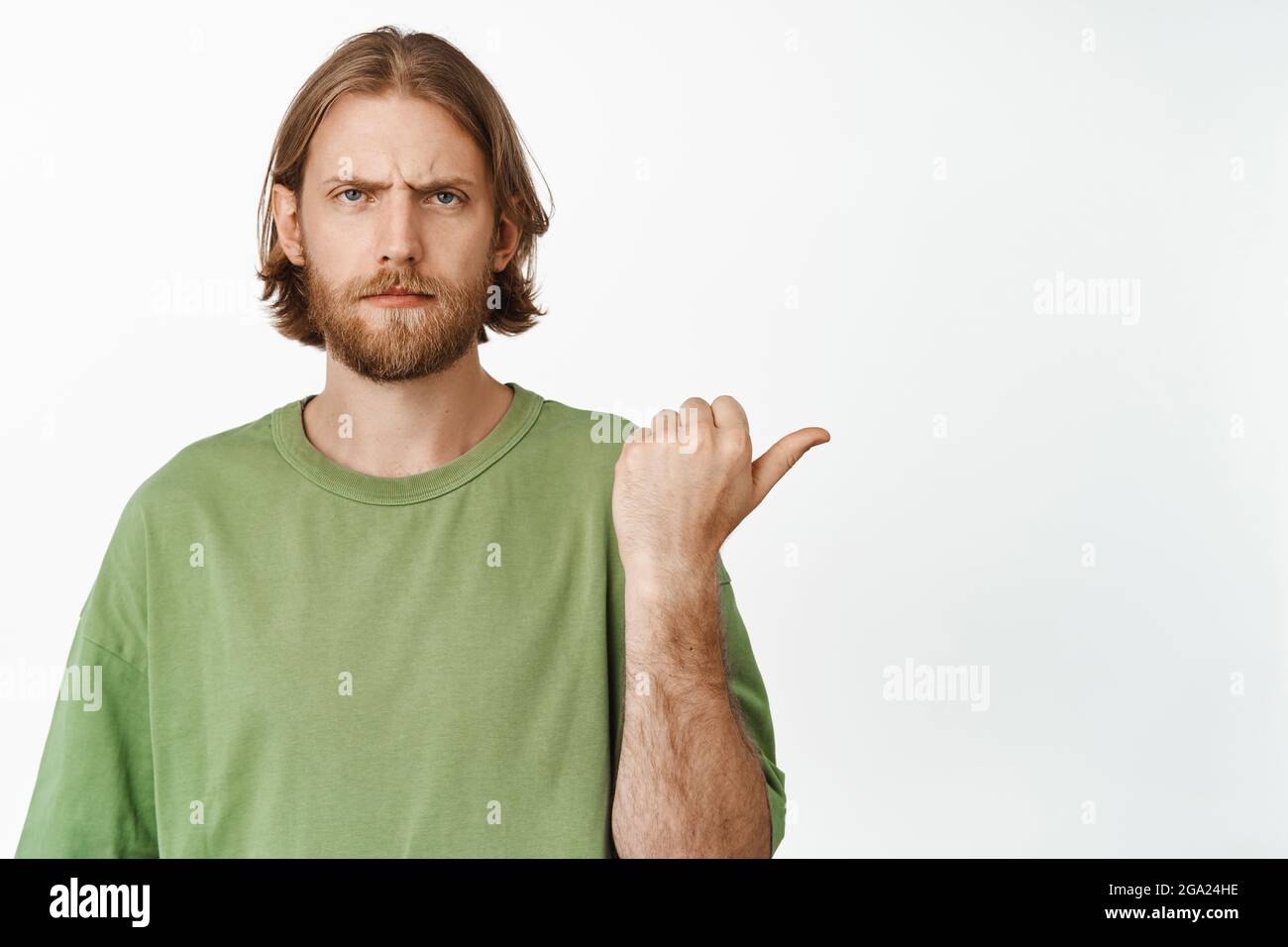 Portrait of disappointed grumpy blond guy pointing right, complaining ...