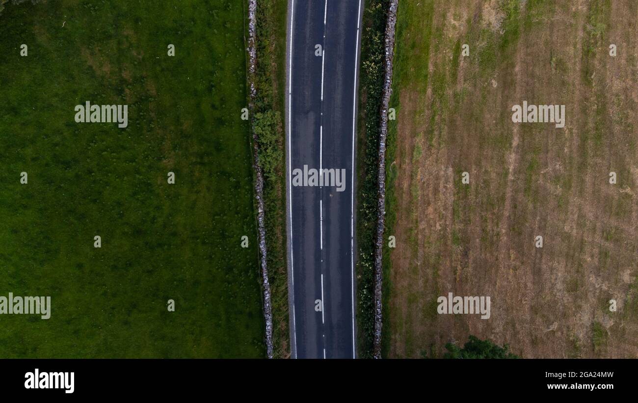 Aerial top-down view of road with cobbled walls and fields either side ...