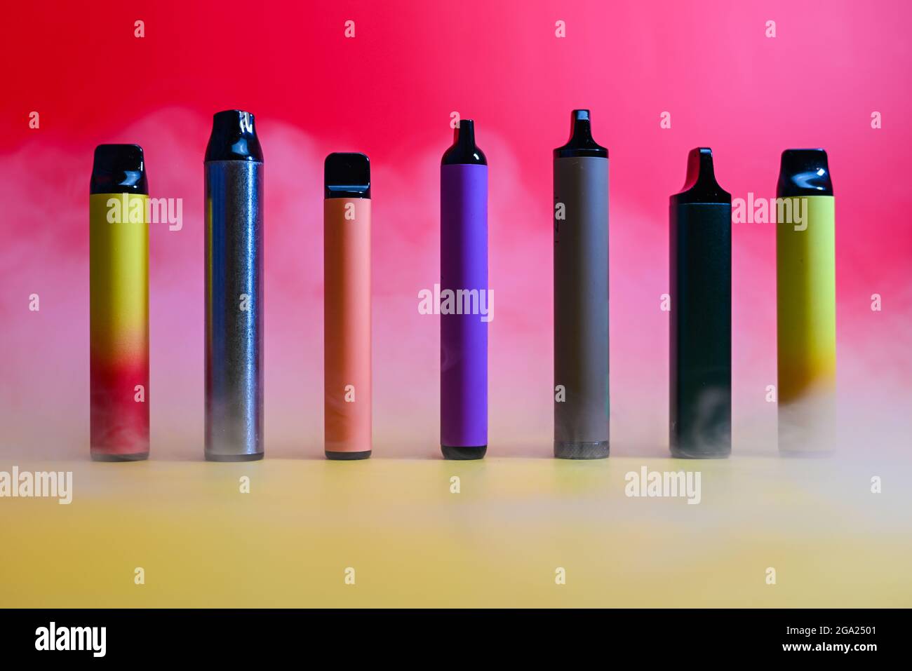 multicolored vape electronic cigarettes on a red background in the ...