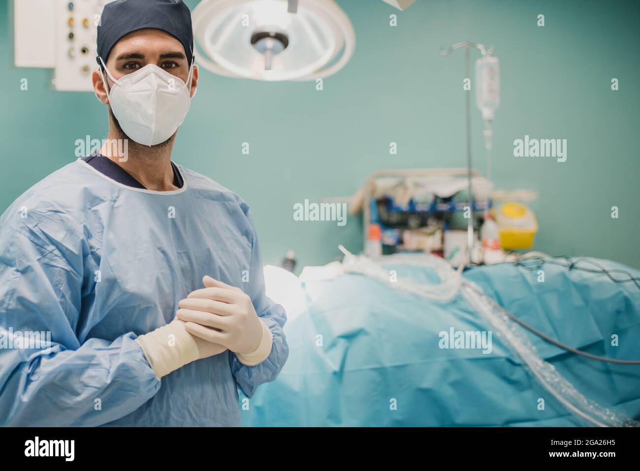 Portrait of medical doctor looking at camera inside operating theater ...