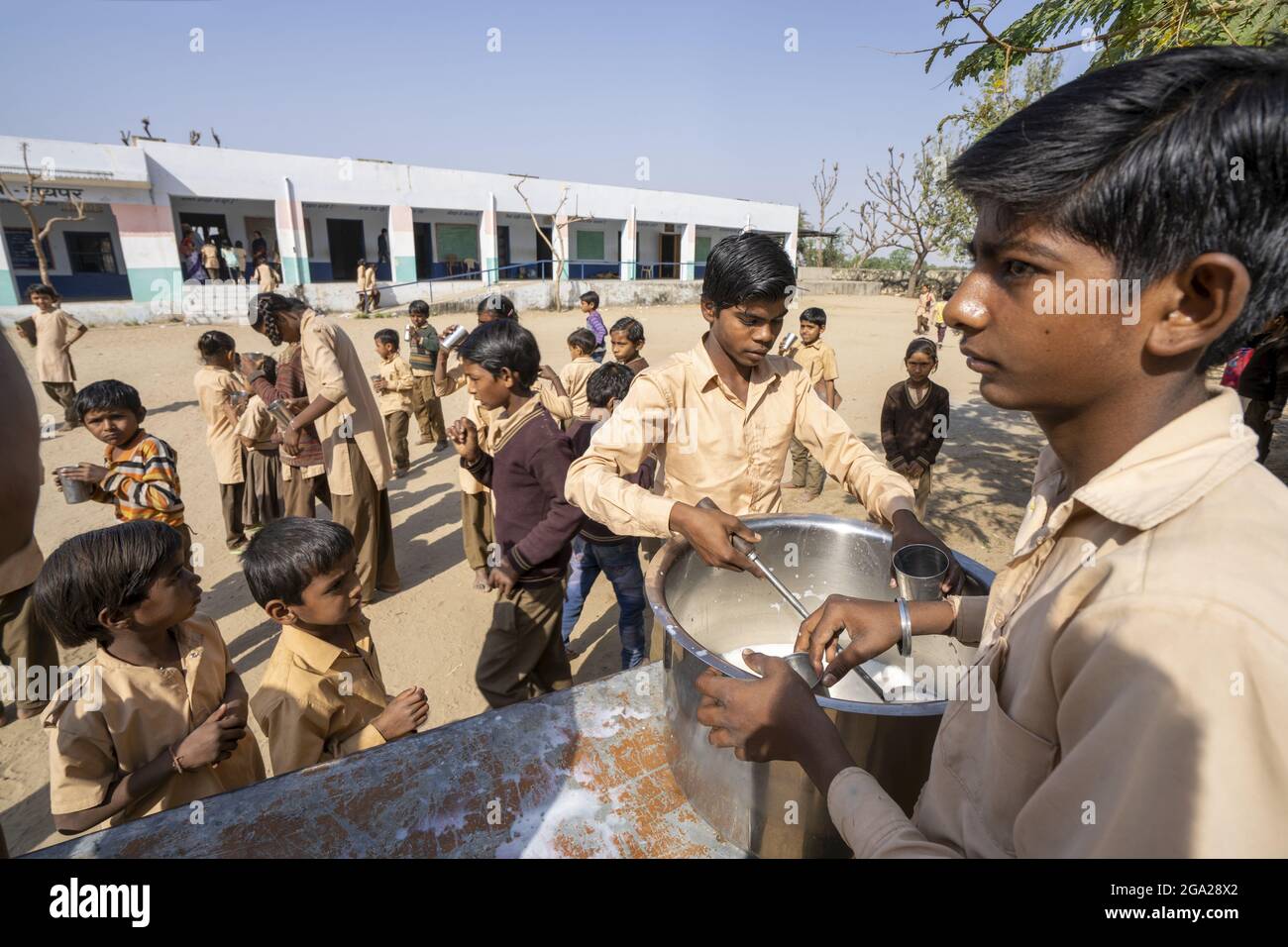 Milk monitors serving milk to children in a rural Village School in ...