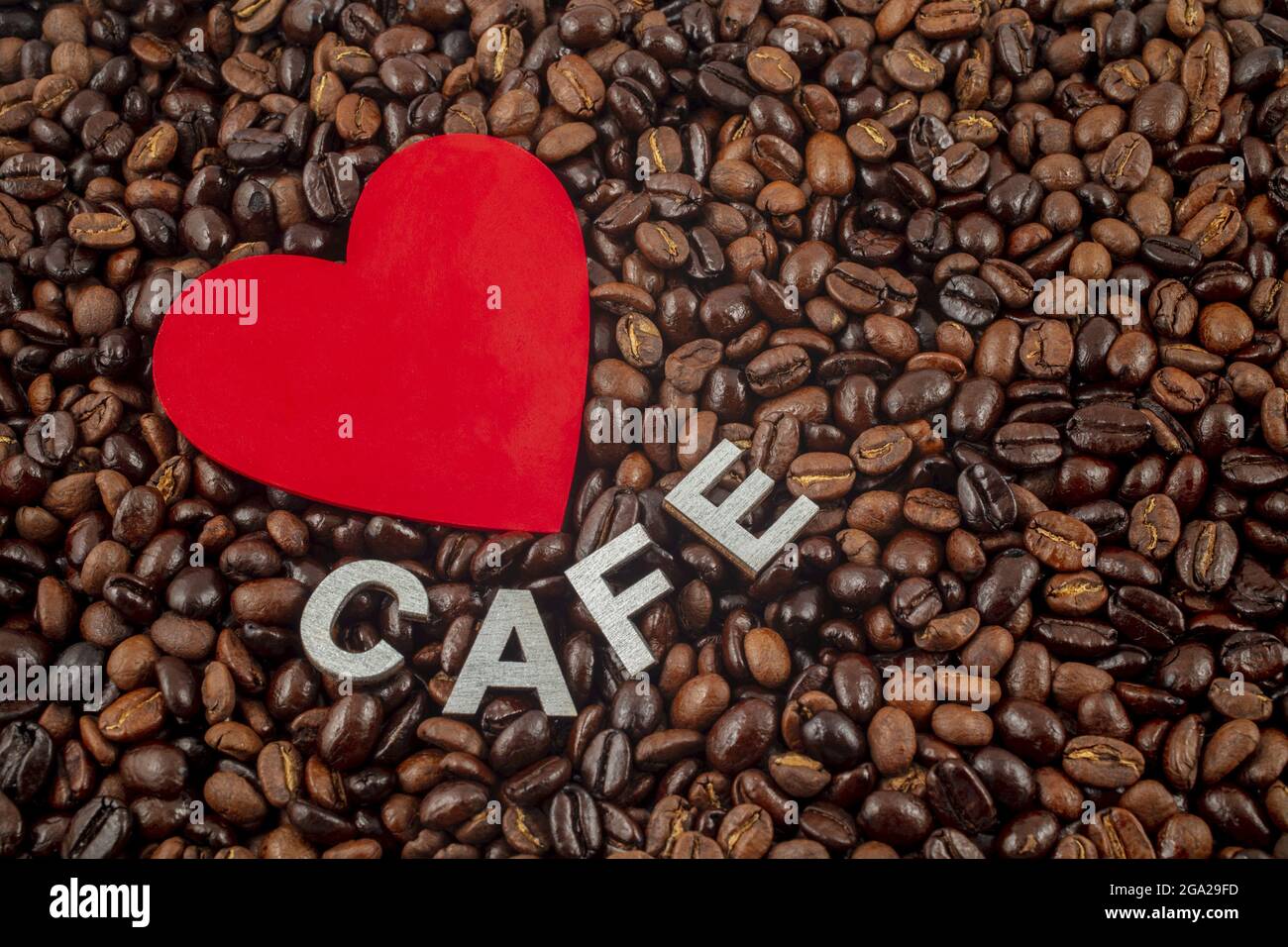 Background of roasted coffee beans with a red heart-shaped cutout and ...