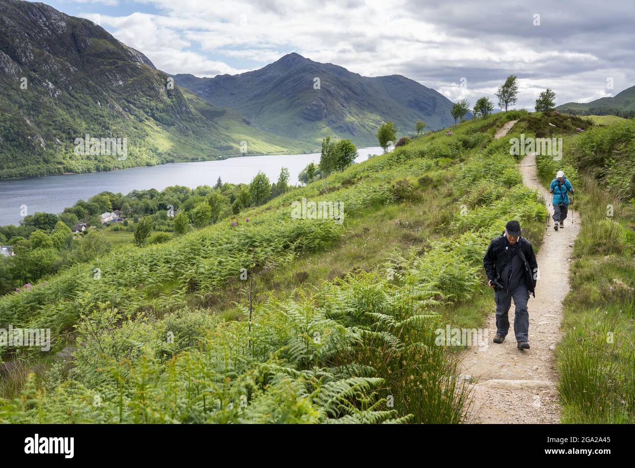 Two hikers walk a path near Glenfinnan, Scotland; Glenfinnan, Scotland ...