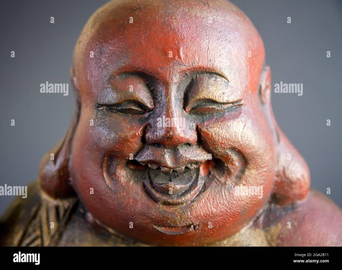 Tradional wooden statue of chinese Buddha isolated on dark background ...