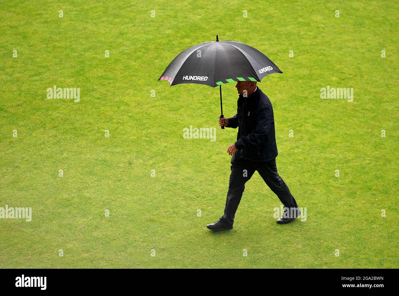 Umpire Graham Lloyd on the pitch before abandoning the fixture due to ...