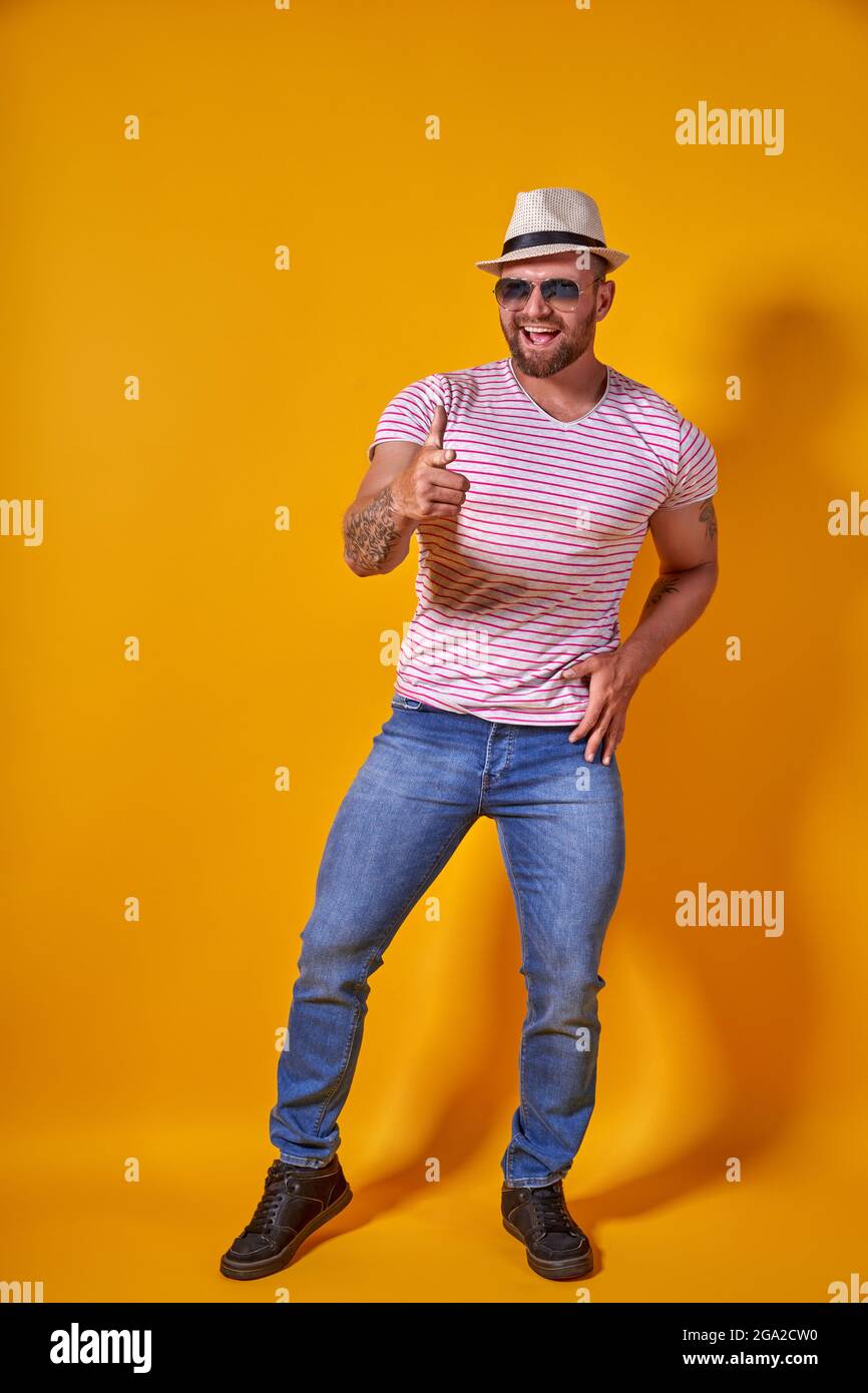 Portrait of optimistic funky guy dance wear summer look straw hat ...