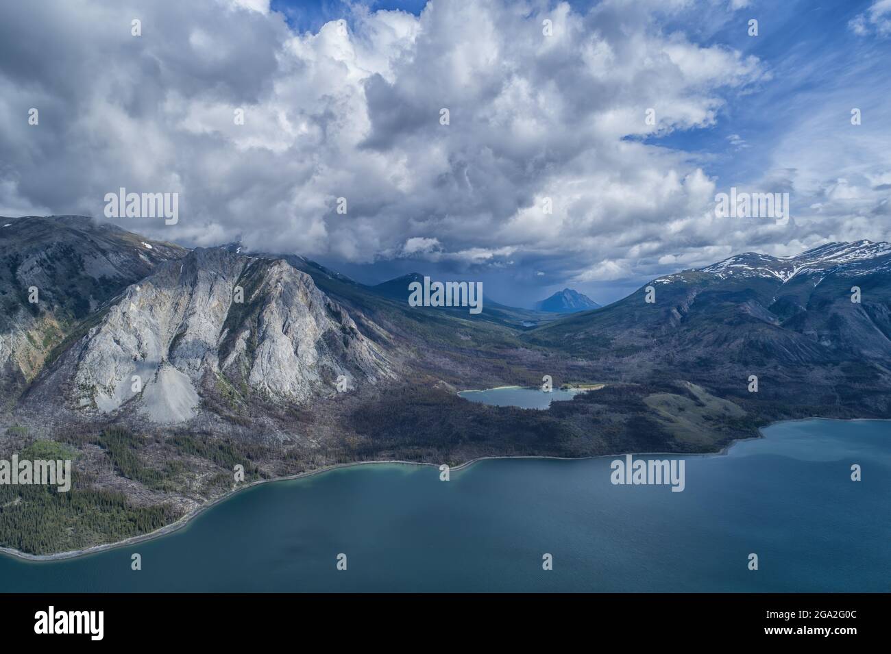 Aerial view of the lakes and dramatic Yukon mountain ranges under a ...