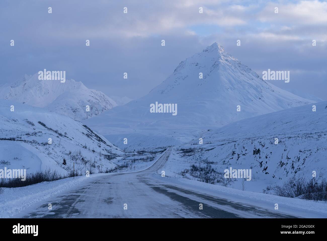 Snowy scene of the Alaska Highway stretching out into the snow covered ...