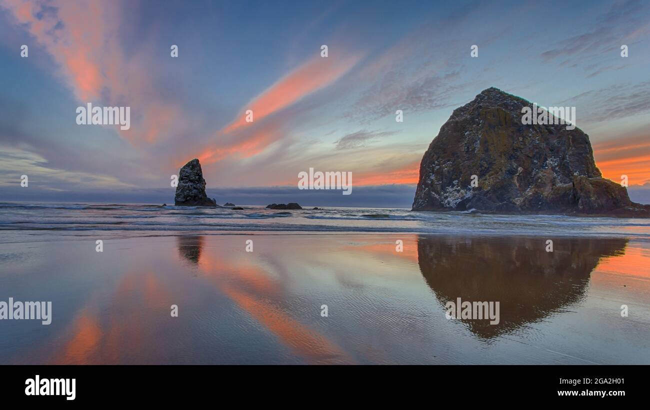 Dramatic sunset light in clouds over beach and rock formations on the ...