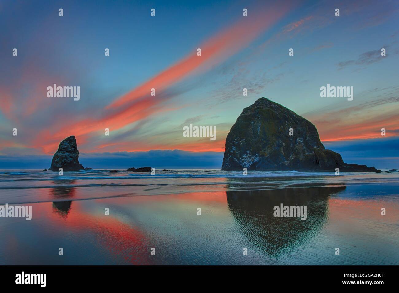 Dramatic sunset light in clouds over beach and rock formations on the ...