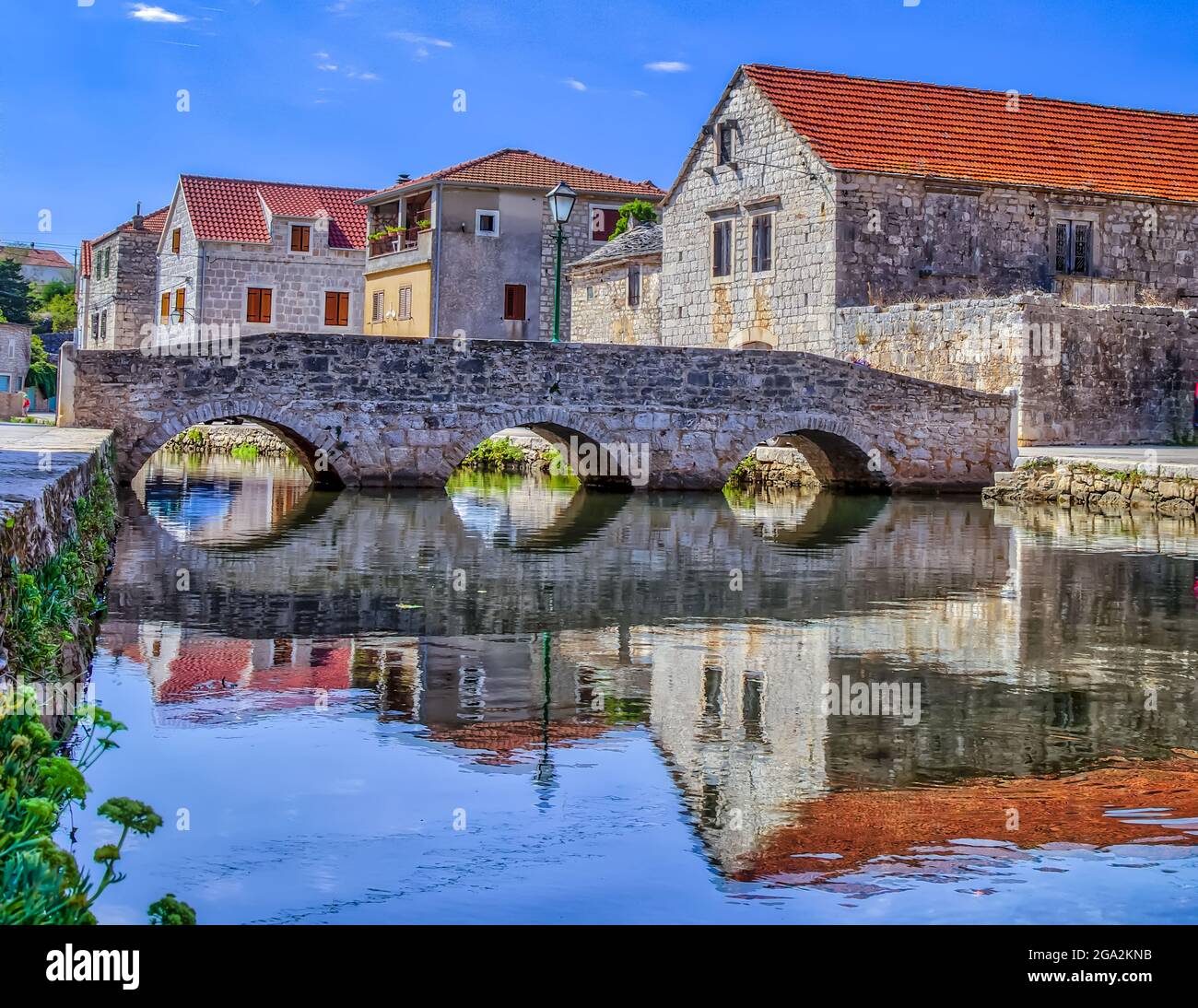 Medieval arch bridge crossing a canal with old stone buildings ...