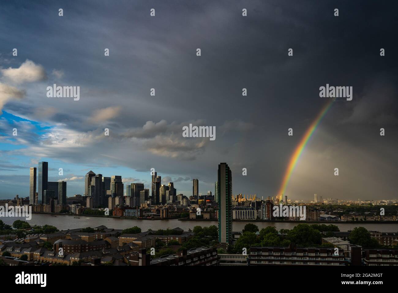 London, UK. 28th July, 2021. UK Weather: A rainbow begins to arc over ...