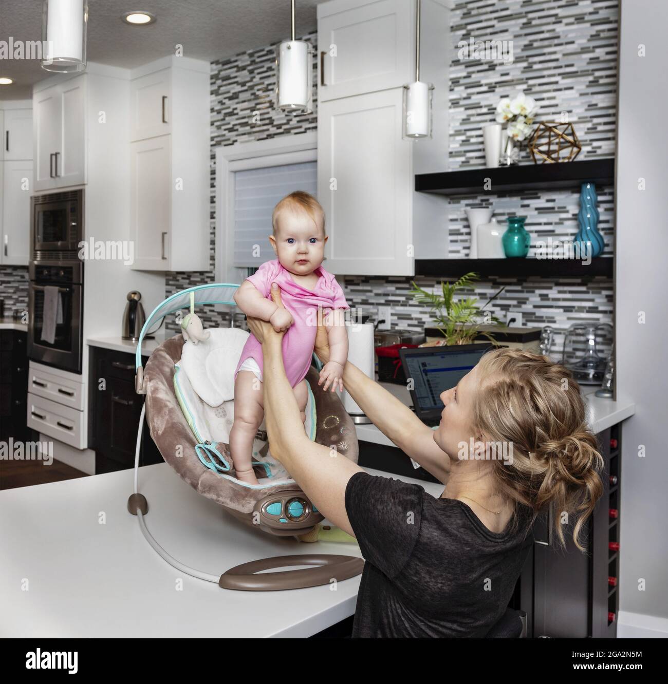 A paraplegic mother in a wheelchair playing with her baby in a baby ...