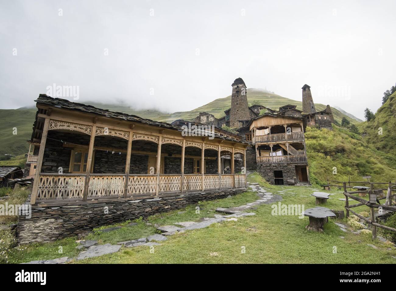Traditional wooden balconies on the stone houses with medieval watch ...