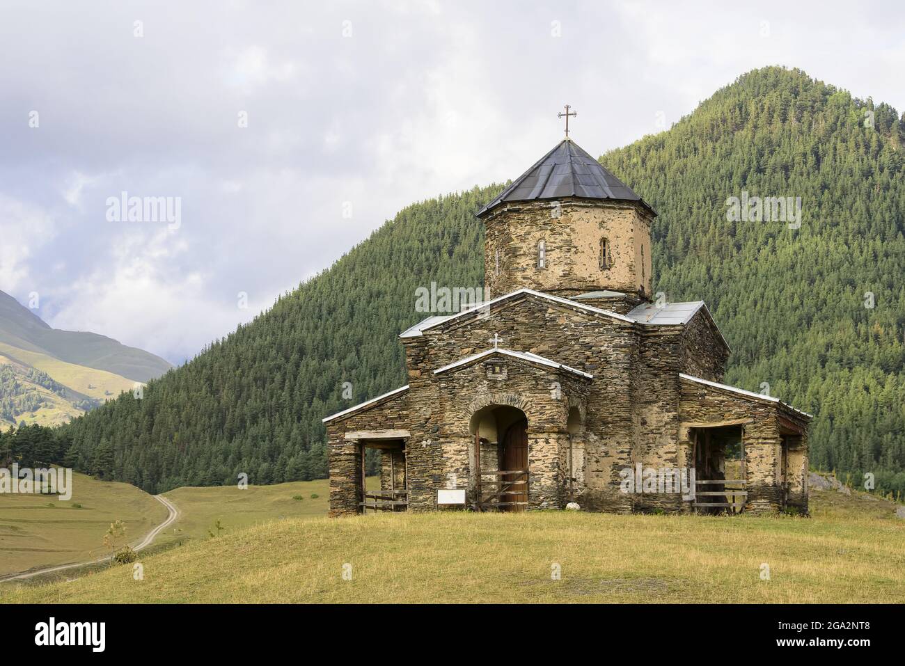 Old Church of the Holy Trinity in Shenako with the forested mountains ...
