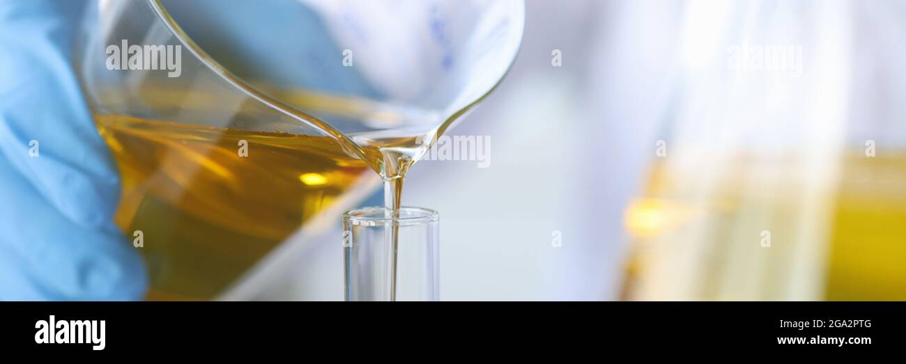 Scientist chemist pouring oil from flask into glass closeup Stock Photo ...