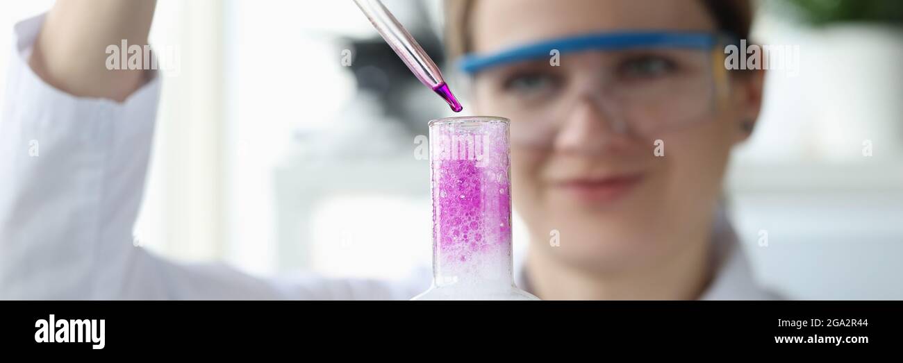 Woman scientist dripping reagent into flask with foamy water Stock ...