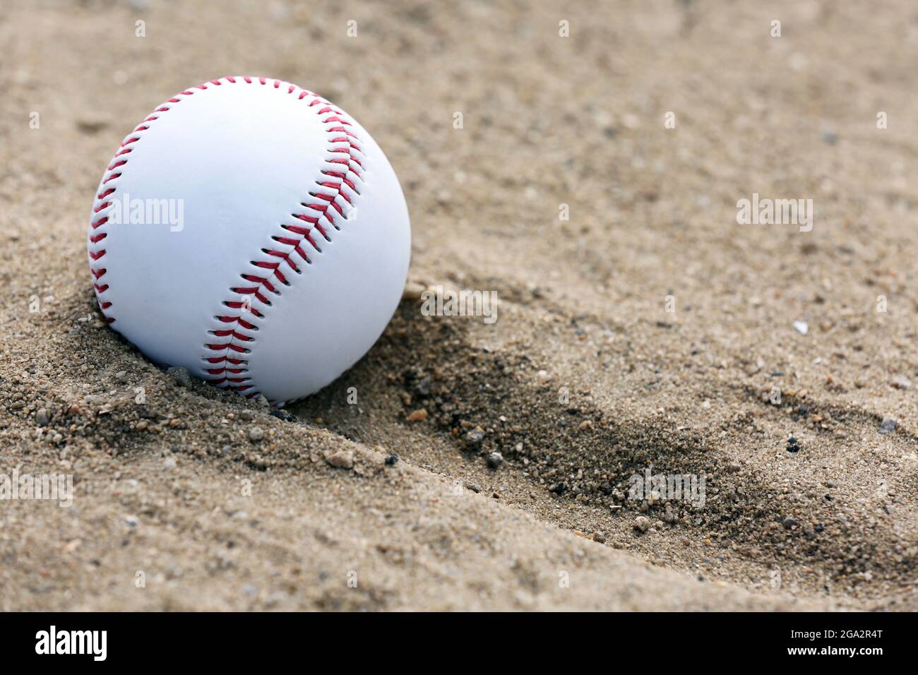 Baseball ball on sand Stock Photo - Alamy
