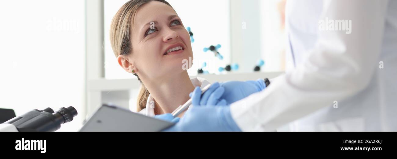 Assistant giving woman chemist clipboard with documents in lab Stock ...