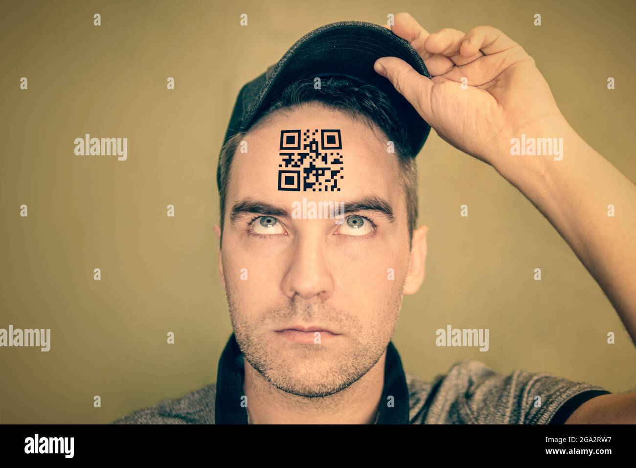A man with a stupid expression looks at his qr code on his head. The ...