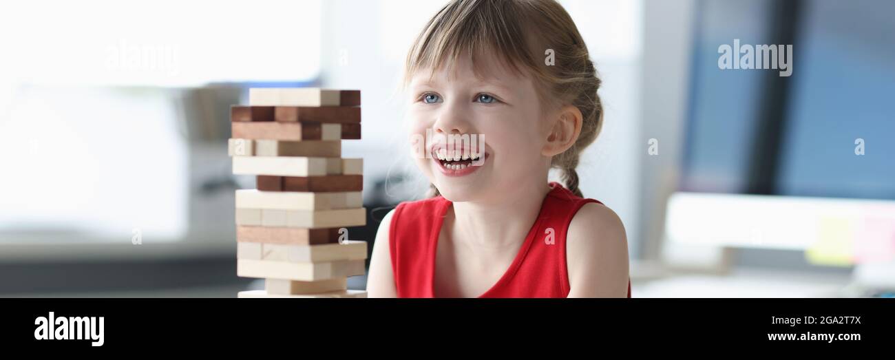 Little girl building tower from wooden blocks Stock Photo - Alamy