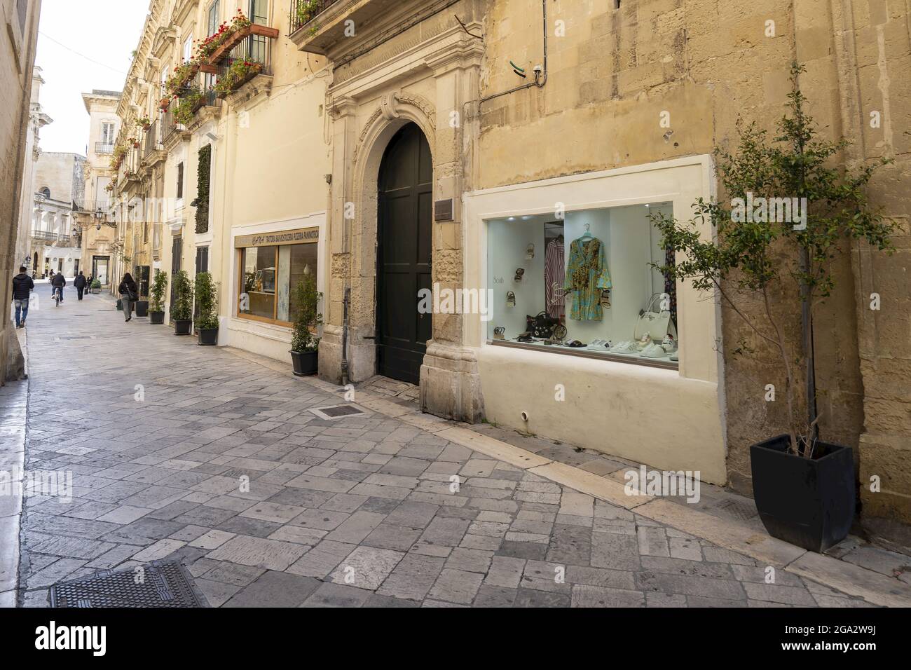 Street scene with people walking past storefronts and the limestone ...