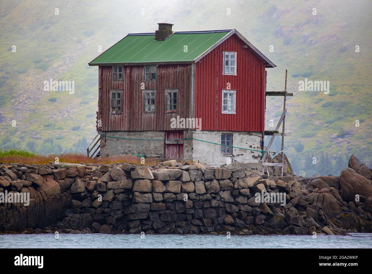 Traditional fishing village house next to the shoreline in Lofoten ...