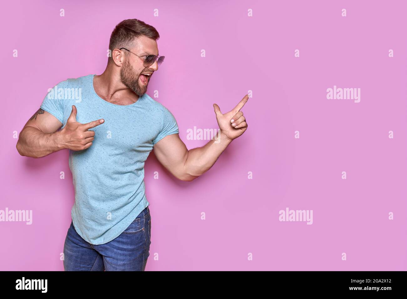 Young excited man on vacation over pink background pointing finger to ...