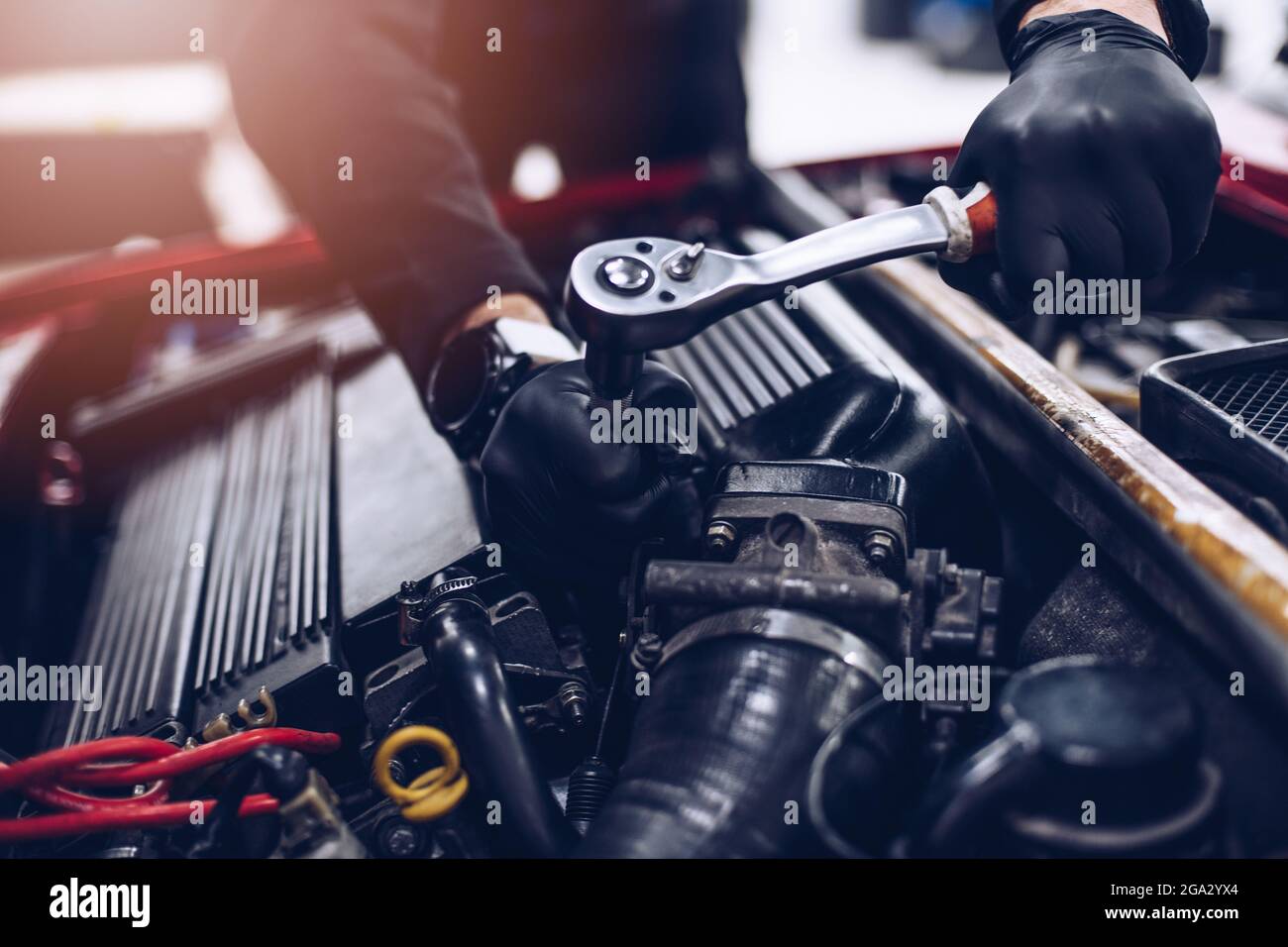 Mechanic in service repairing engine with wrench Stock Photo - Alamy