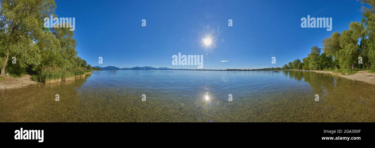 Lake Chiemsee with a sunburst in a blue sky on a sunny day with ...