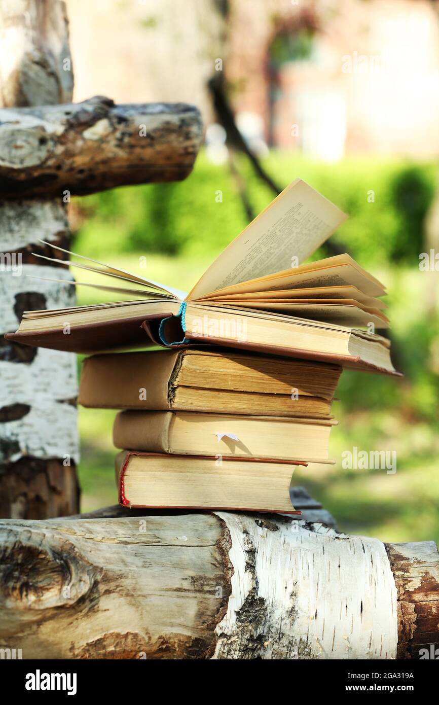 Stack of books on bench, outdoors Stock Photo - Alamy