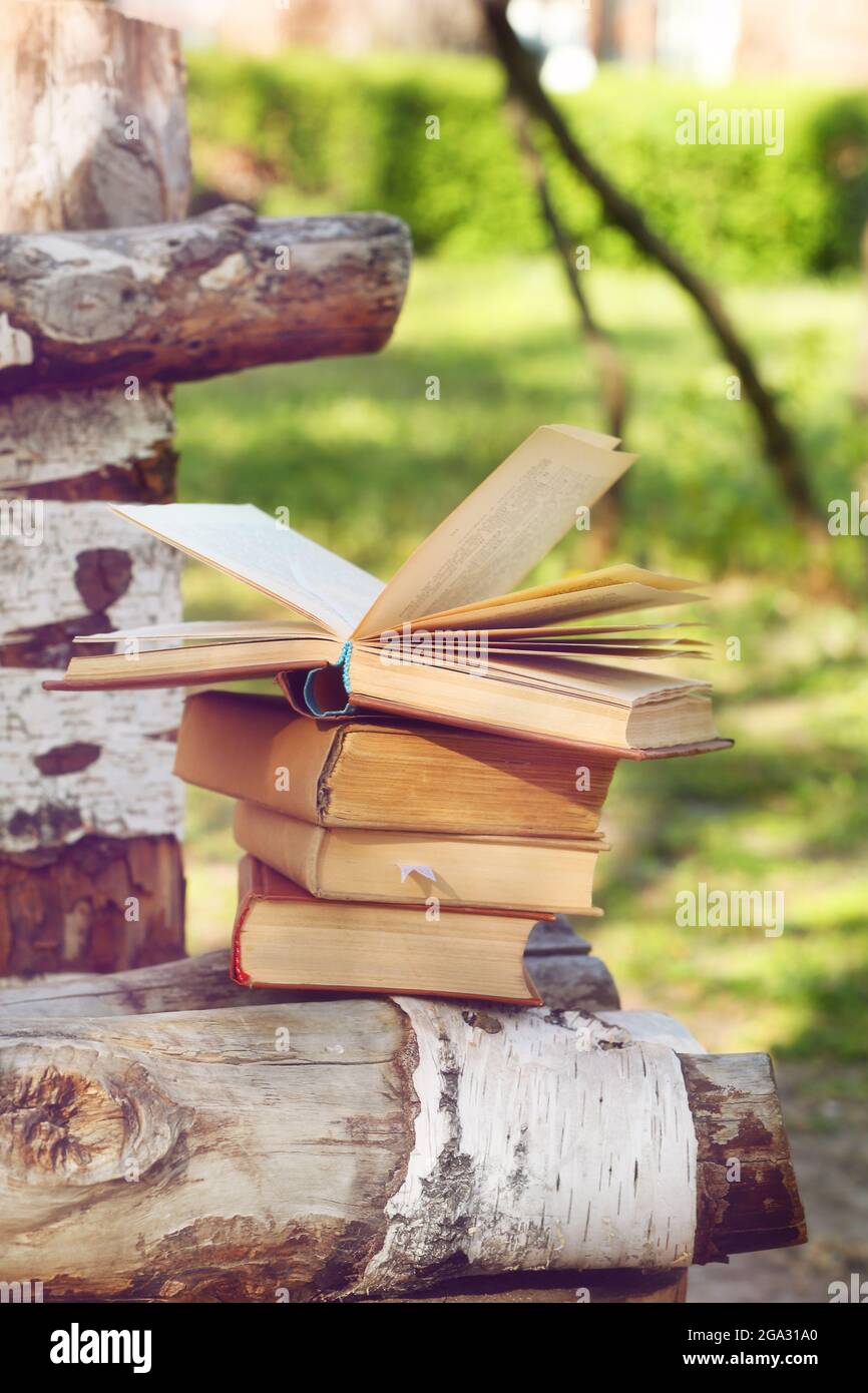 Stack of books on bench, outdoors Stock Photo - Alamy