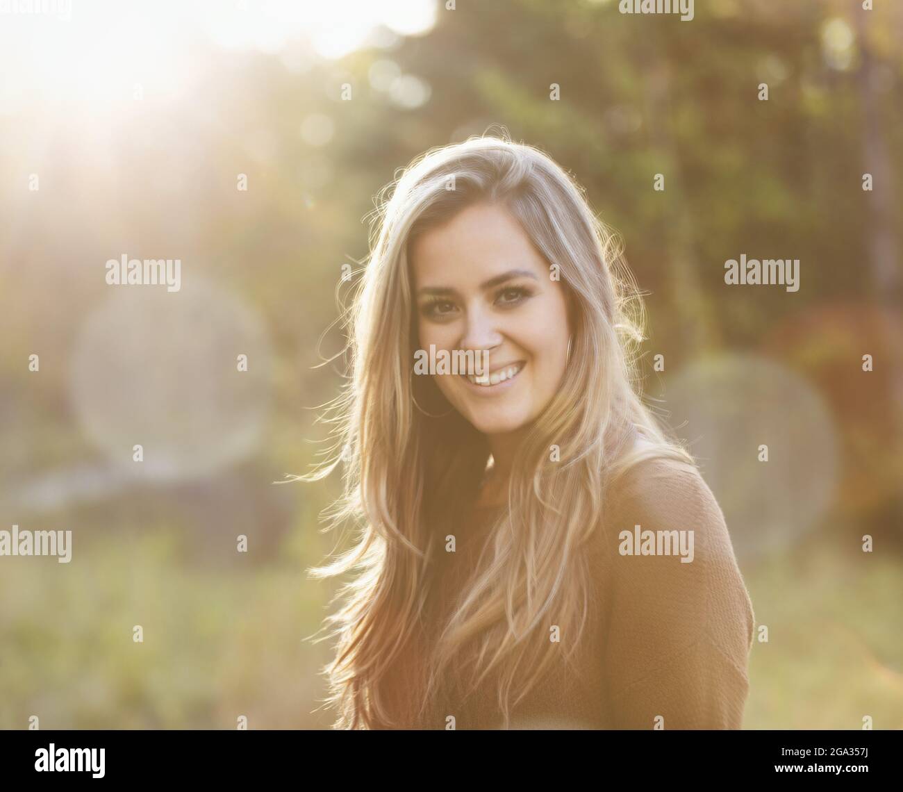 Portrait of a beautiful young woman in a city park; Edmonton, Alberta ...