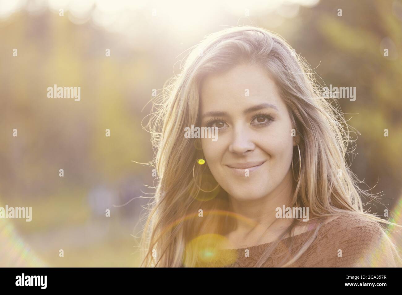 Portrait of a beautiful young woman in a city park; Edmonton, Alberta ...