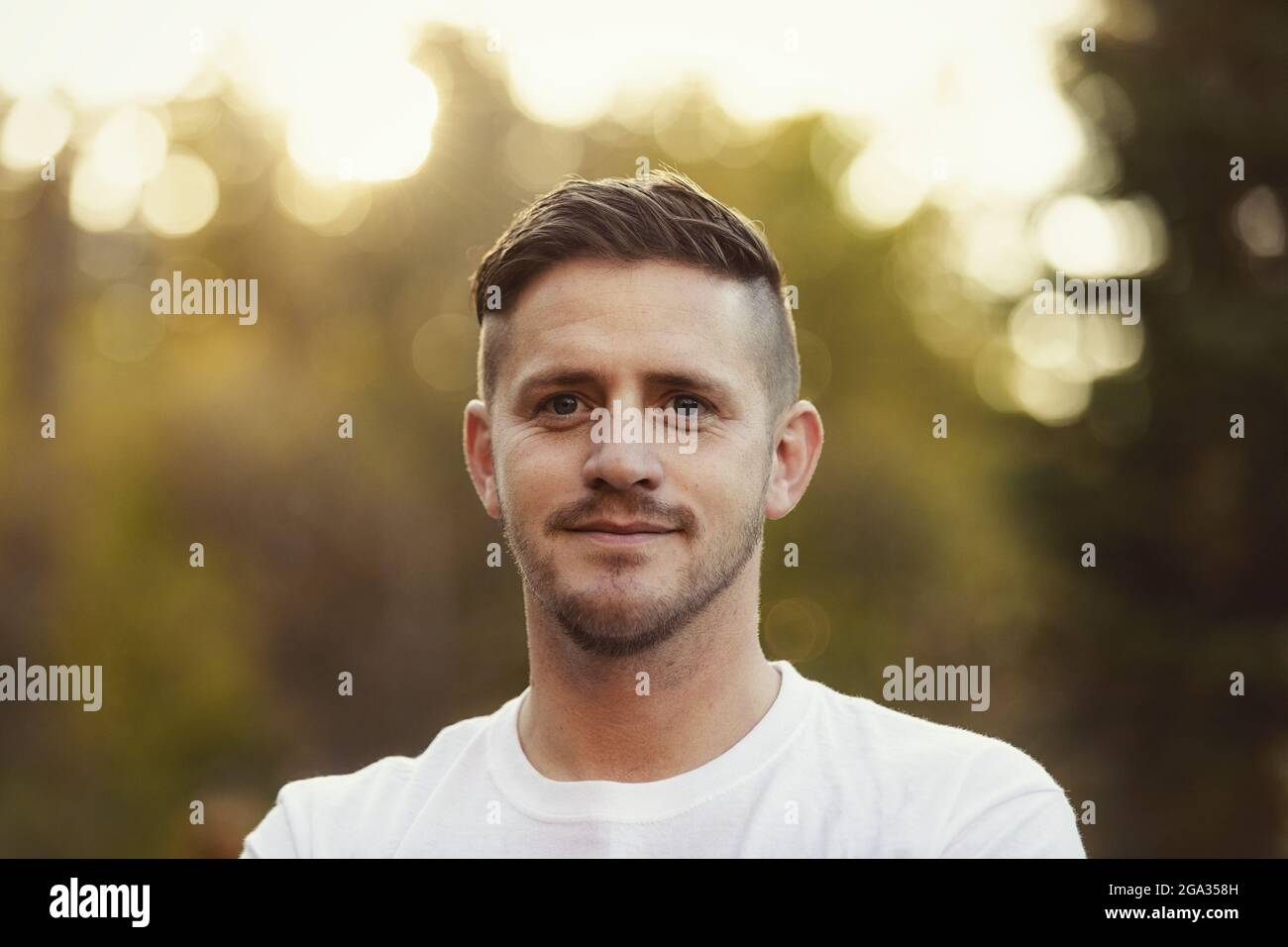 Portrait of a man outdoors in a city park during the fall season ...