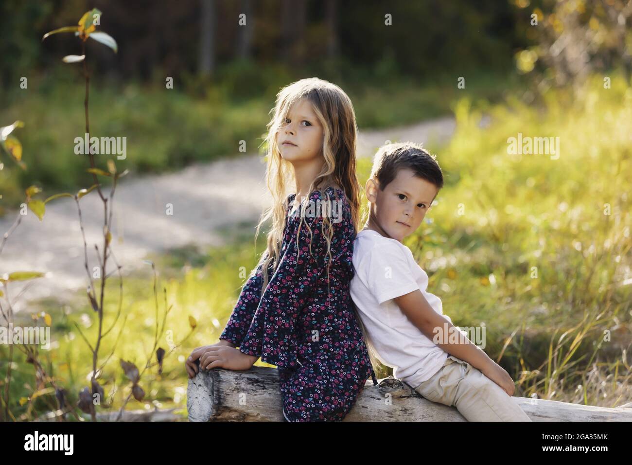 Portrait of a young brother and sister together outdoors in a city park ...