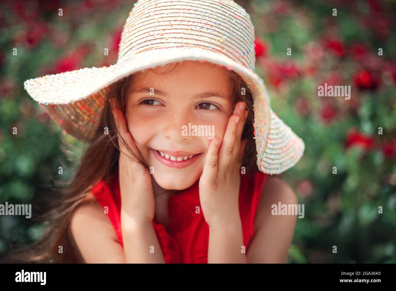 Beautiful little girl in roses garden in park. Charming woman smiling ...