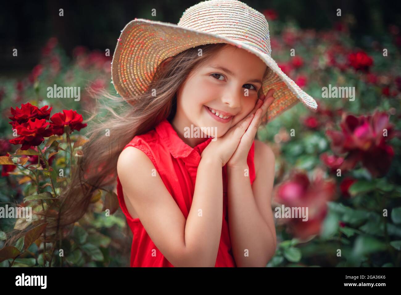 Beautiful little girl in roses garden in park. Charming woman smiling ...