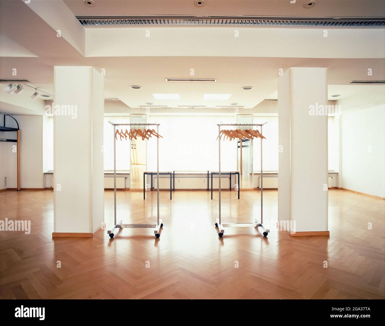 Coat hangers on portable coat racks in an empty room; Germany Stock ...