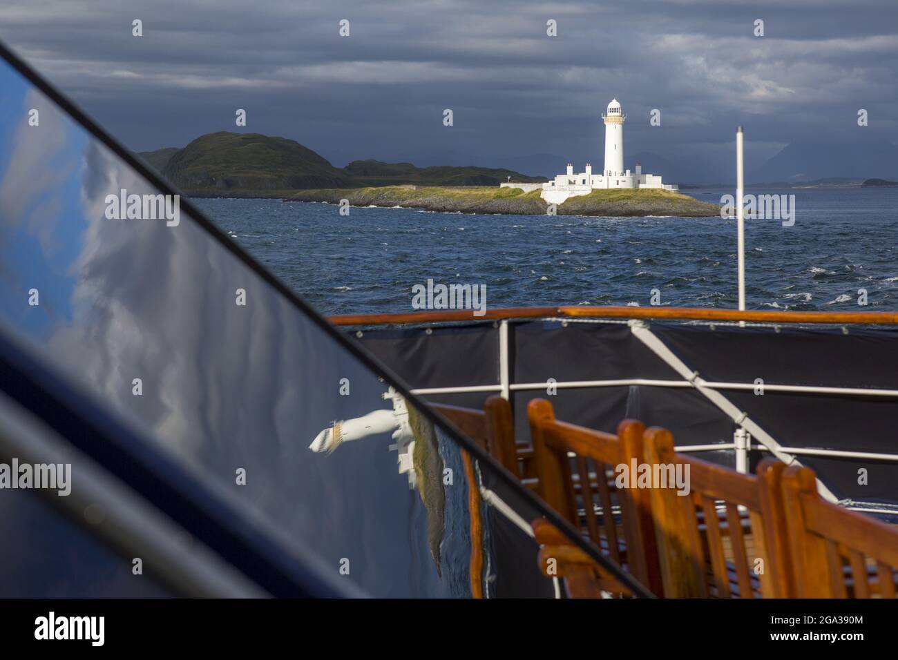A lighthouse off the coast of Isle of Mull, Scotland, is illuminated ...