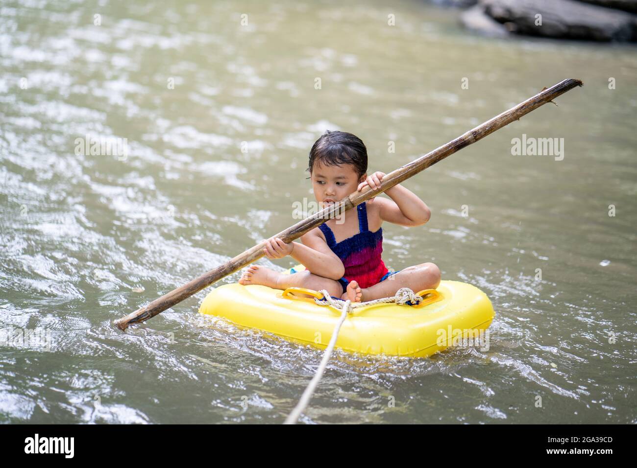 Asian cute female child rowing in a yellow raft Stock Photo - Alamy